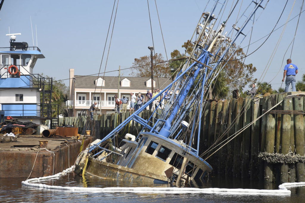 An American 7260 Crawler Crane mounted on a barge works to raise Three ...